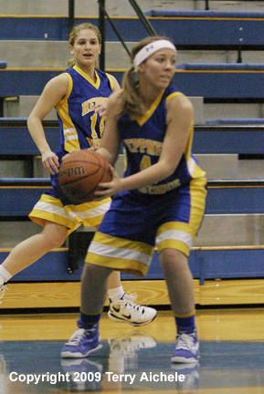 LEFT - A Riverside player in white is closely defended by Torri ...