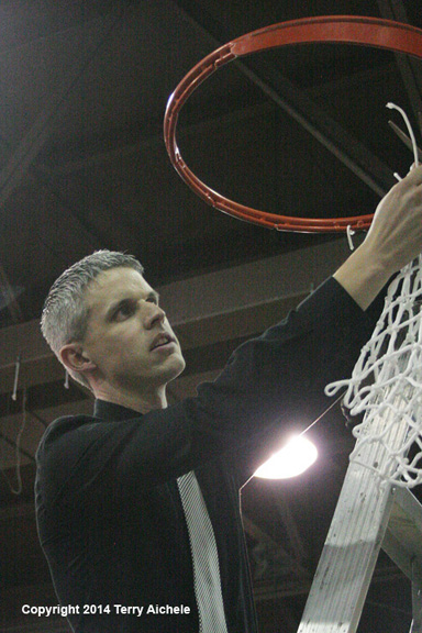 Irrigon head coach Jake McElligott finishes cutting the net then turns ...