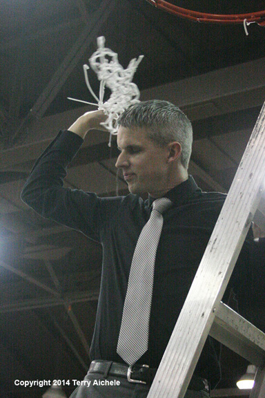 Irrigon head coach Jake McElligott finishes cutting the net then turns ...